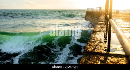 Crisp Cornish waves rising up from the reef of Porthleven at sun set ...
