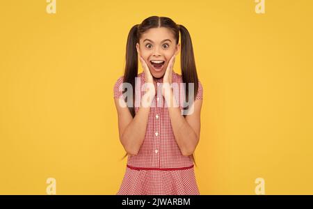 Shocked eye-popping tween girl show surprise yellow background, OMG ...