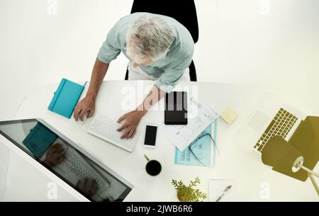 Getting down to business. Shot of a mature businessman working on a ...