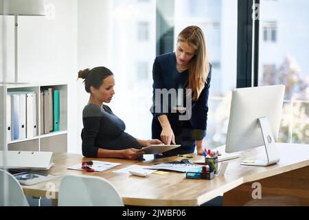 Balancing work while expecting. a pregnant businesswoman and a ...