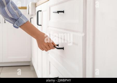 Woman opening drawer in light kitchen, closeup Stock Photo - Alamy