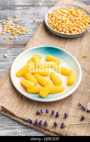 Jelly corn candies on gray concrete background and linen textile. top ...
