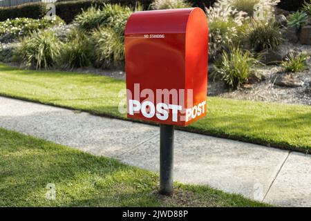 A red australia post letter box stripped of all branding and logos ...