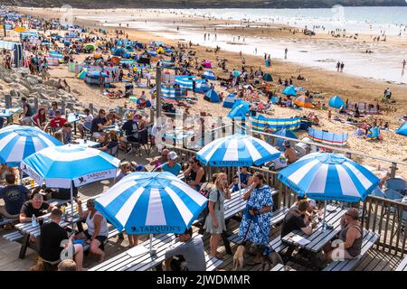 Holidaymakers on a busy crowded Fistral Beach in Newquay in Cornwall in ...