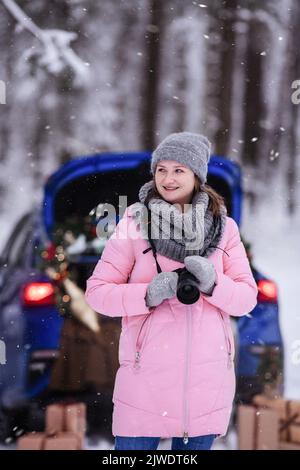 Female photographer in warm clothes takes pictures of nature outdoors ...