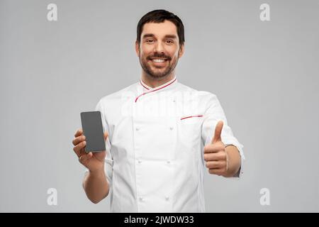 happy chef with smartphone showing and thumbs up Stock Photo - Alamy