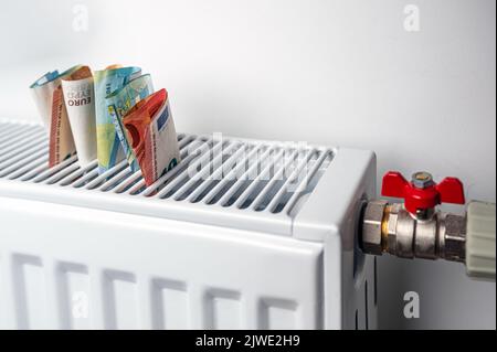 euro banknotes in a central heating radiator, the concept of expensive ...