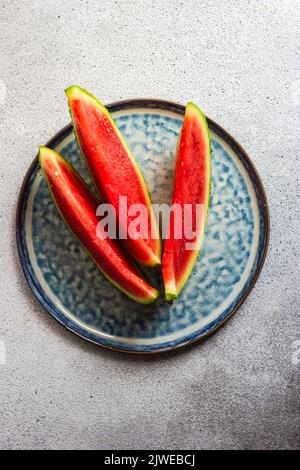 A row of three watermelon slices on black reflective surface Stock ...