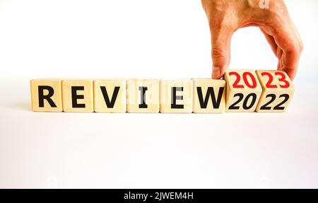 2023 review new year symbol. Businessman turns a wooden cube and ...