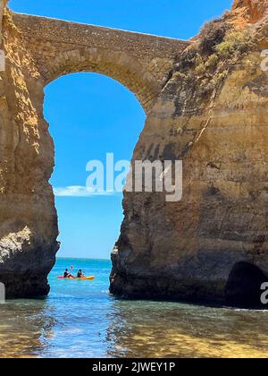The scenic Roman bridge in Lagos connecting the cliffs over the beach ...