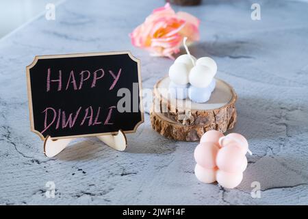 small bubble candles and blackboard with happy diwali written in chalk ...