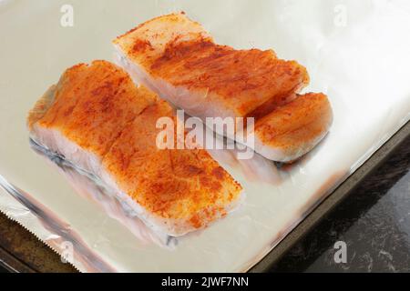 Two baked barramundi fish fillet slices with paprika spice rub on ...