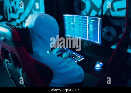 Hacker in hoodie working hacks code site on personal computer. War and ...
