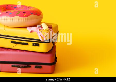Suitcases with bottle of sunscreen, bikini bra, passports, tickets and ...