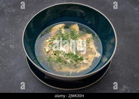 Transparent chicken broth with dill, consomme, on a dark background ...