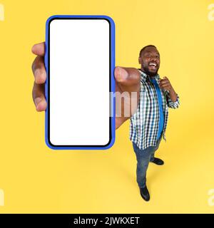 Excited Black Guy Showing Huge Smartphone Screen Over Yellow Background ...