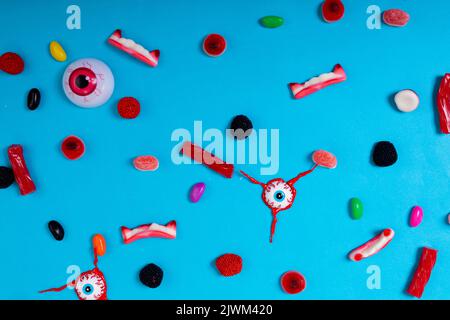 Multiple scary eyes toys and halloween candies on blue surface Stock ...