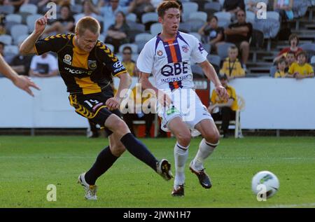 The Central Coast Mariners' Matthew Simon (right) is tackled by Mickael ...