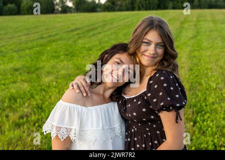 happy mom hugs her teenage daughter against a green field Stock Photo - Alamy