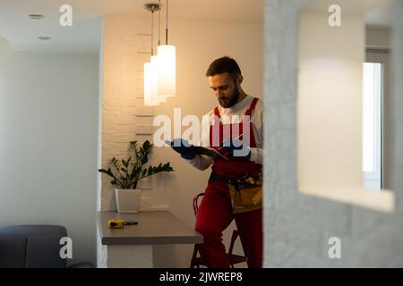 Installation lighting. Builder is holding a tablet in his hands ...