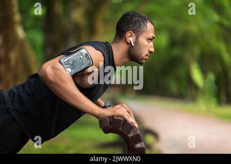 Motivated muscular arab guy exercising in the park, copy space Stock ...
