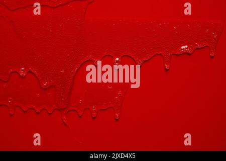 Cream liquid gel serum flows down red silver texture Stock Photo - Alamy
