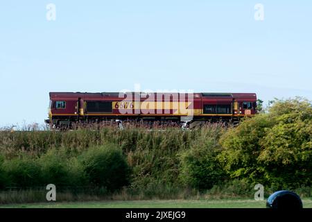 DB class 66 diesel locomotive No.66012 pulling a freight train, side ...