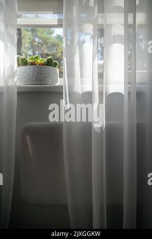 Electric heating radiator under window with curtains in living room ...