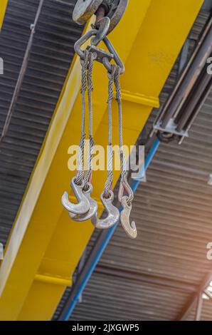 Metal hooks of lift in assembly shop. Lifting device, lifting hook at ...
