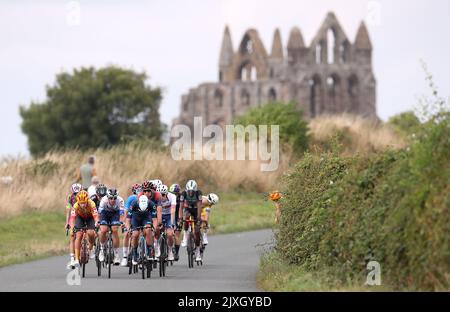 The peloton passes Whitby Abbey during stage four of the AJ Bell Tour ...