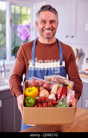 Portrait Of Mature Man Unpacking Online Meal Food Recipe Kit Delivered ...