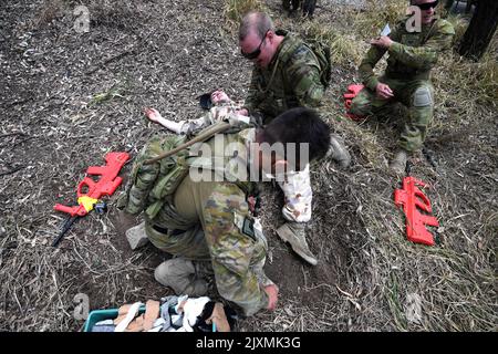Soldiers from Australia's 7th Combat Brigade carry a US marine playing ...