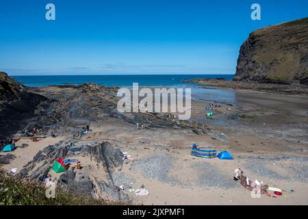 View of Crackington Haven Beach with holidaymakers enjoying the sun and ...