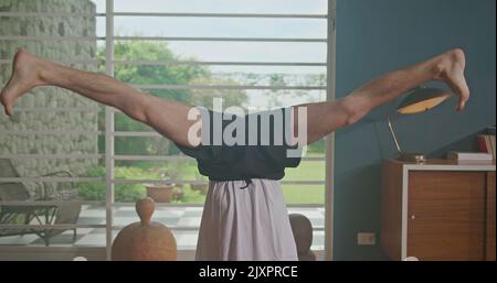 Athlete man balances upside down in yoga practice. Person practicing ...