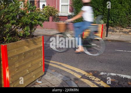 A cyclist passes through barriers signalling a controversial LTN (Low ...