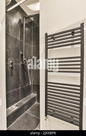 Shower faucets attached to tiled wall near glass partition and ...