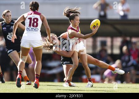 Jade Ellenger of the Lions is tackled by Charlotte Wilson of the Blues ...