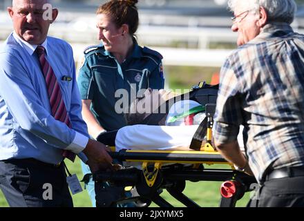 Jockey Clayton Gallagher is taken away by paramedics after he was ...