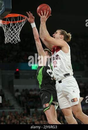 Sam Froling (right) of the Hawks shoots over Tyrell Harrison (left) of ...