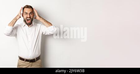 Frustrated man panicking, shouting and looking anxious, standing over ...