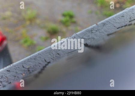 A portrait of a roof gutter overflowing with water during a rainy day ...