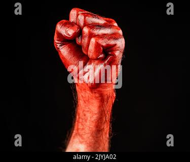 Bloody male fist on a black background. Copy space Stock Photo - Alamy