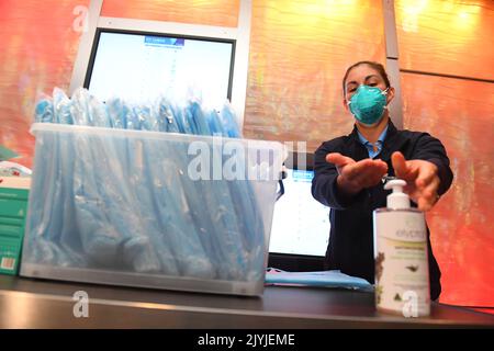 A Healthcare worker donning PPE at a personal protective equipment ...