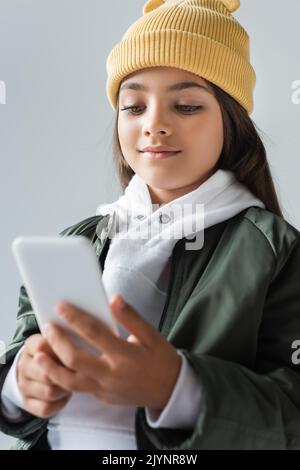 happy kid chatting on smartphone in classroom at blackboard, message ...