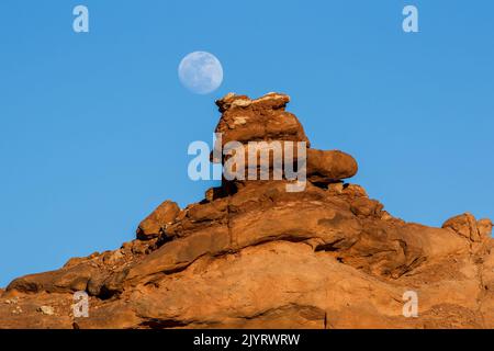 Rising moon behind an Entrada sandstone rock formation in Arches ...