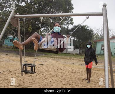 Yarrabah children Isiah and Jakian play in the rain on park swings in ...