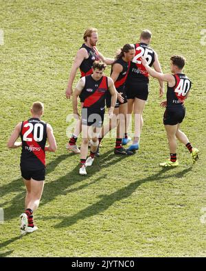 Archie Perkins of Essendon (right) celebrates with team mates after ...