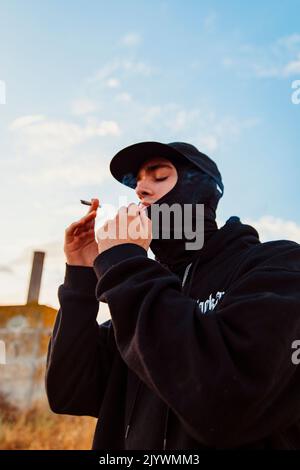 Guy with balaclava smoking a joint of marijuana Stock Photo - Alamy