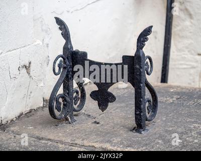 Old Victorian cast iron boot shoe mud scraper set in brick wall. Many ...