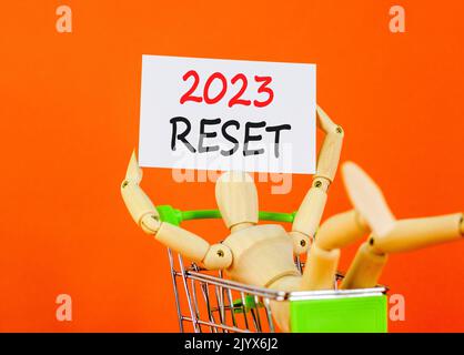 2023 Reset symbol. White paper with words 2023 Reset, clip on wooden ...